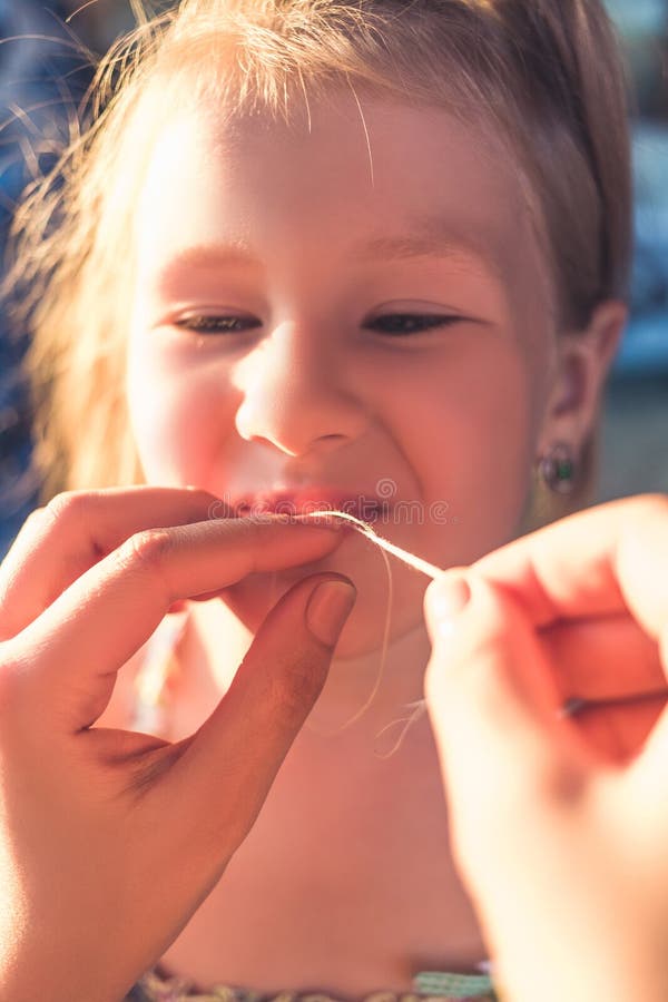 The Process of Removing a Baby Tooth Using a Thread Stock Image - Image ...