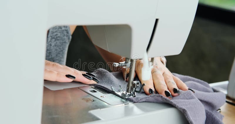 The Process of Sewing Clothes Using a Machine. Close-up of the Hands of ...