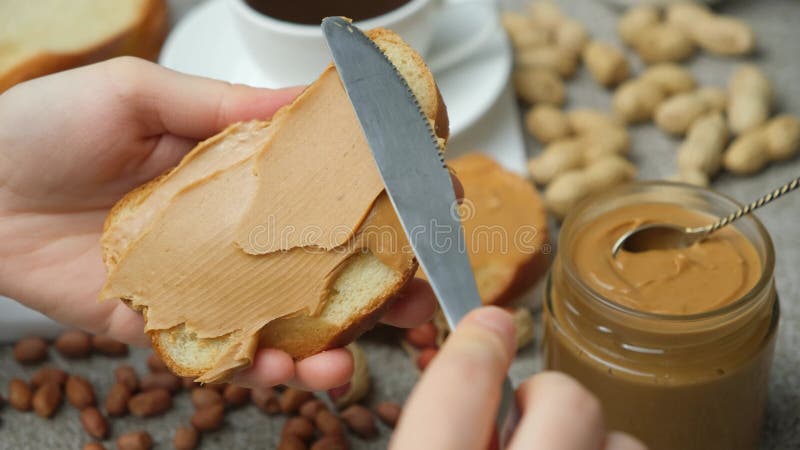 The Process of Spreading Peanut Butter on Bread, Hands Close-up Stock ...
