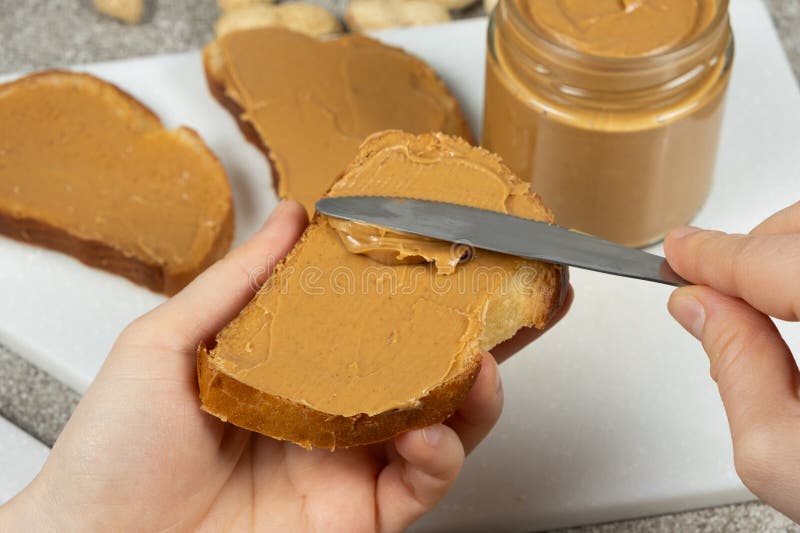 The Process of Spreading Peanut Butter on Bread, Hands Close-up Stock ...