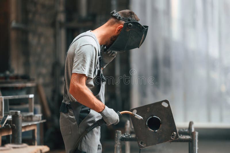 Process of Welding. Young Factory Worker in Grey Uniform Stock Image ...