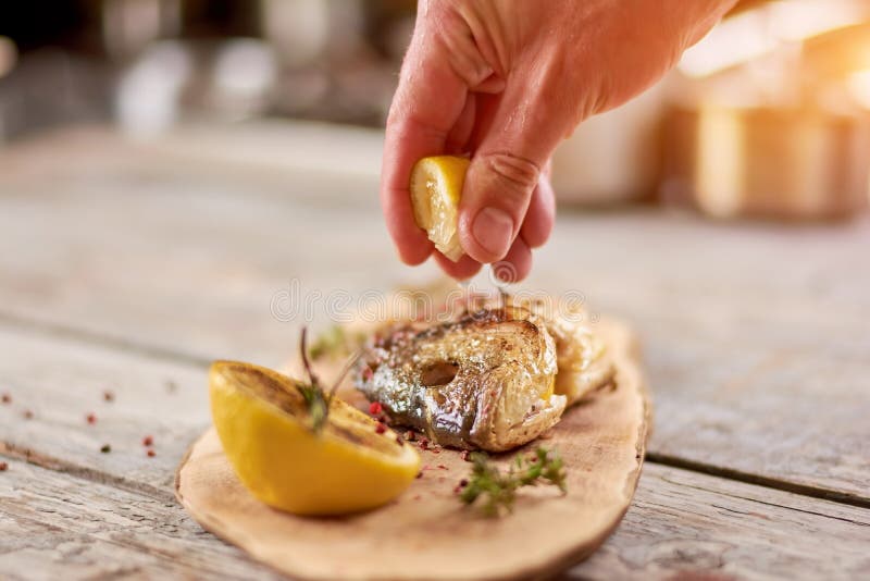 Processing of Grilled Fish with Lemon Juice. Stock Photo - Image of ...