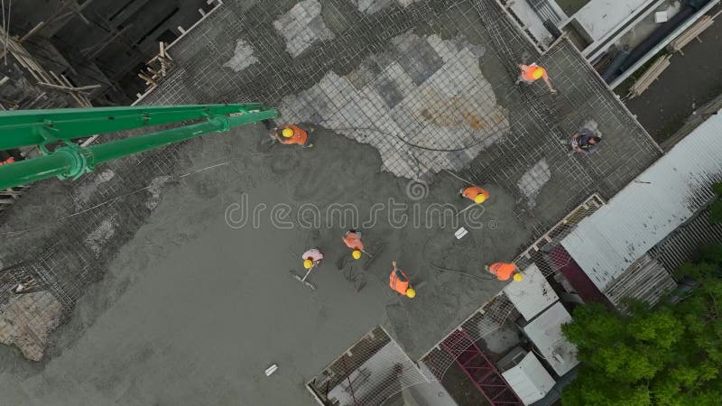 Aerial View: Heavy Machinery and Workers Pour Concrete while Engineers ...