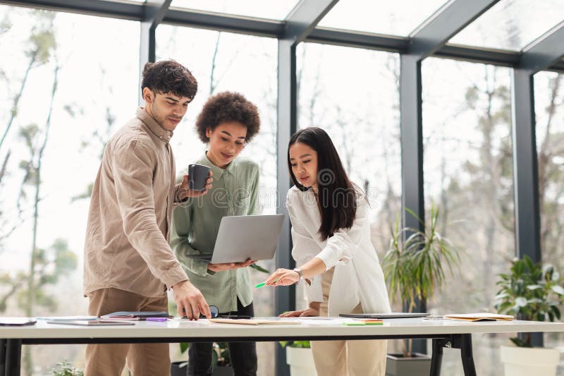 Three Multicultural Colleagues Using Laptop Brainstorming Standing in ...