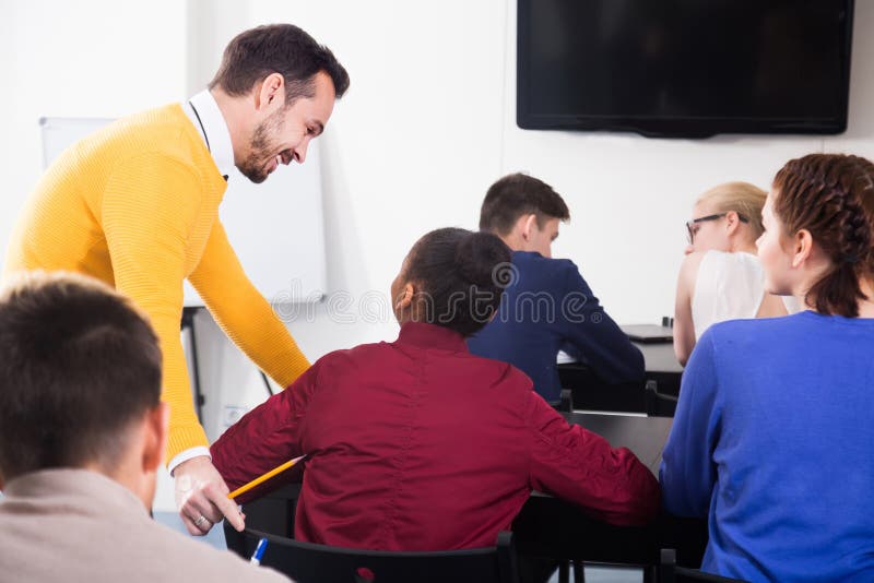 Profesor De Sexo Masculino Que Aclara El Problema Complicado Al Alumno Durante Examen Foto De