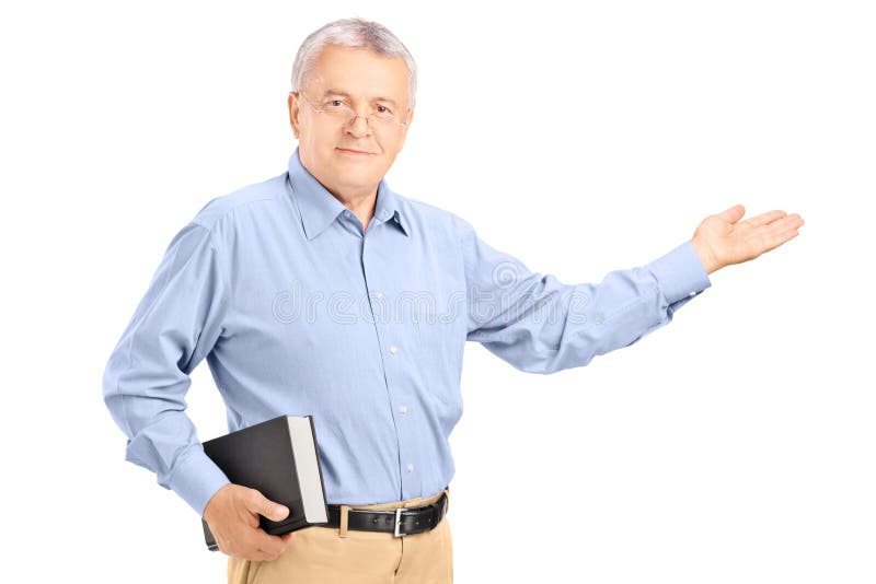 Profesor De Sexo Masculino Que Sostiene Un Libro Y Que Gesticula Con Su Mano Imagen De Archivo