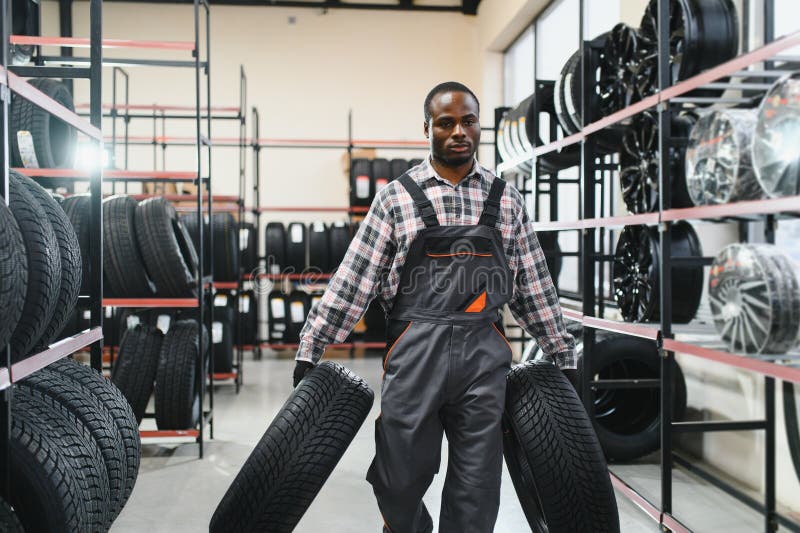 Professional African American Worker with Tire. Man is in the Tire ...
