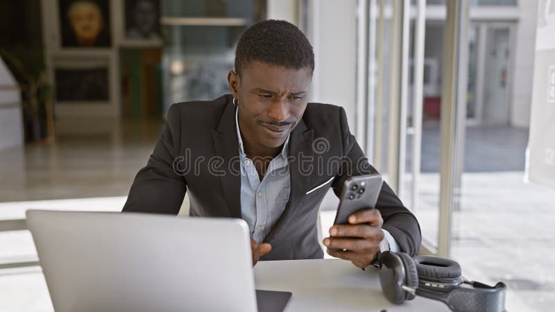 A Professional African Man in a Suit Working with a Laptop and ...
