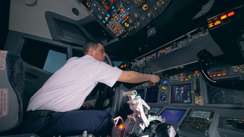 Professional Aiplane Pilot is Turning Indicators on a Cockpit Cabin ...