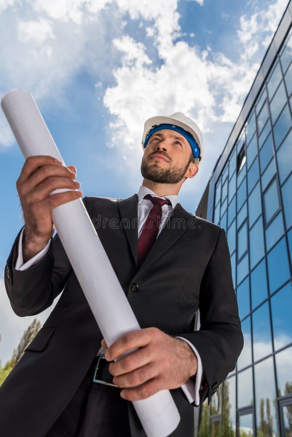 Professional Architect in Hard Hat Holding Blueprint Outside Modern ...