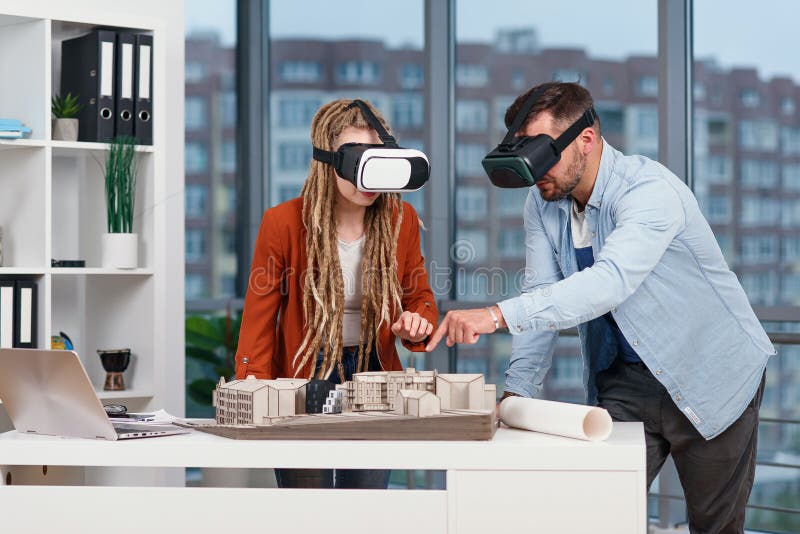 Group of Young Architects at VR Goggles Working with Mock-up of a House ...
