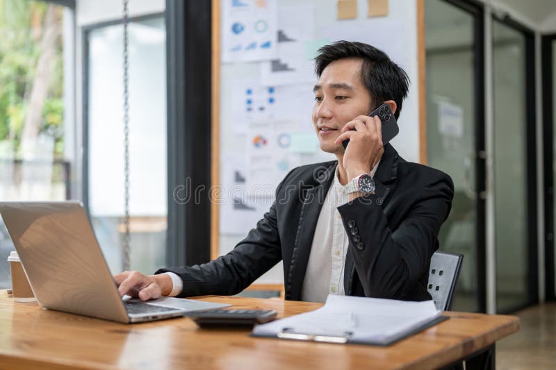 A Professional Asian Businessman is Calling His Client while Working at ...