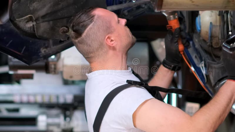 A Professional Auto Mechanic Changes Engine Oil in an Engine at a Bus ...