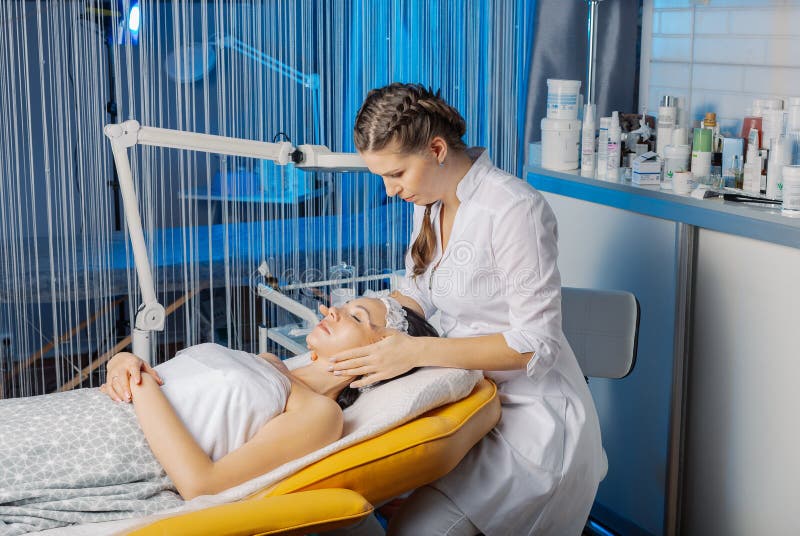 Professional Beautician Makes A Facial Massage To A Woman Stock Image