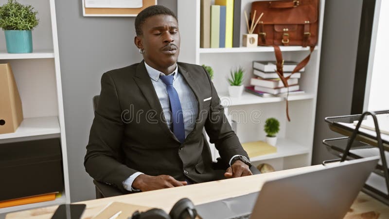 A Professional Black Man in a Suit Works Focused at His Laptop in a ...