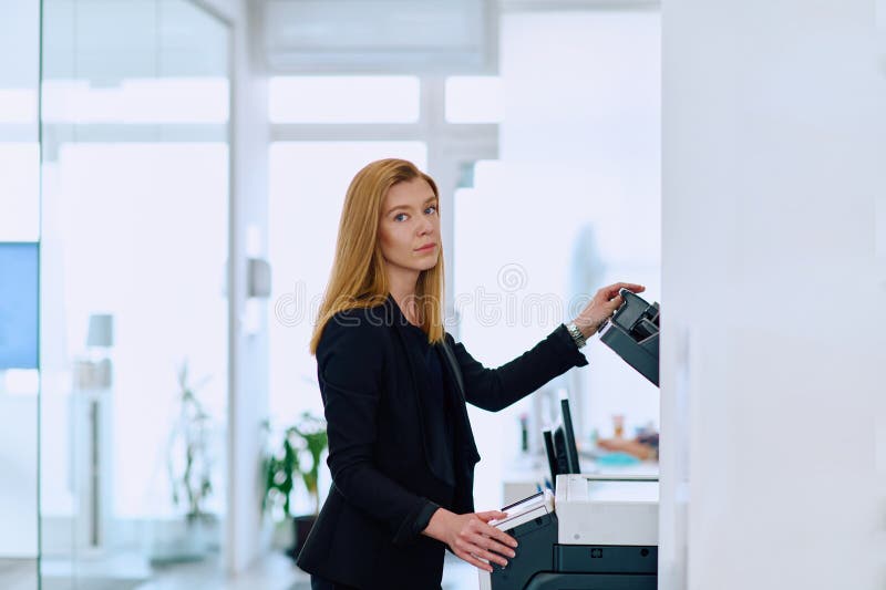 Blonde Businesswoman Using Printer in Office Setting. Stock Photo ...