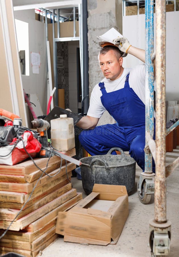 Professional Builder Checking Tools and Materials while Getting Ready ...