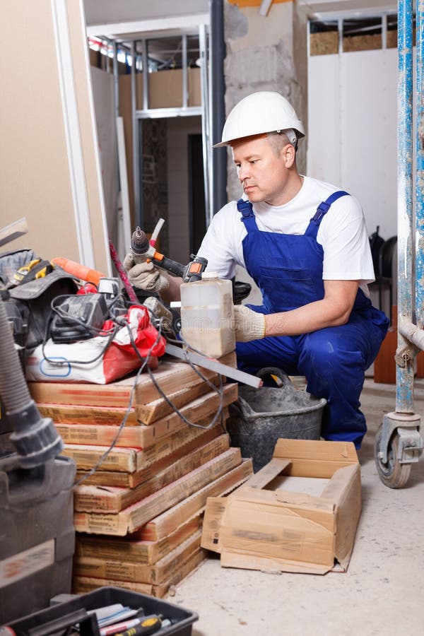 Professional Builder Checking Tools and Materials while Getting Ready ...