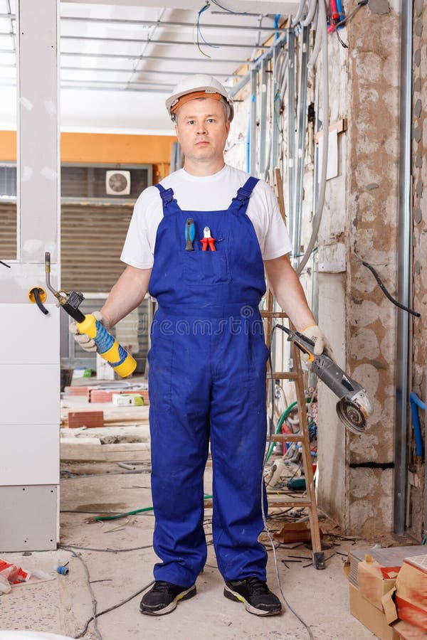 Professional Builder Handyman Working with Angle Drive Grinder Indoors ...