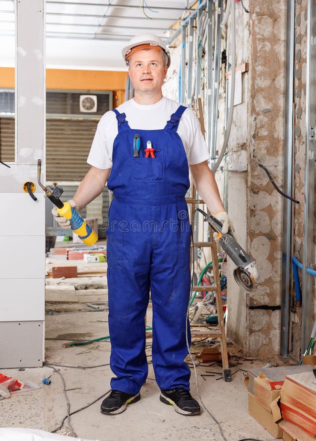 Professional Builder Handyman Working with Angle Drive Grinder Indoors ...