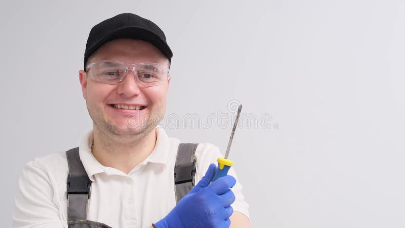 Professional Builder with a Screwdriver in His Hands, he is Smiling and ...