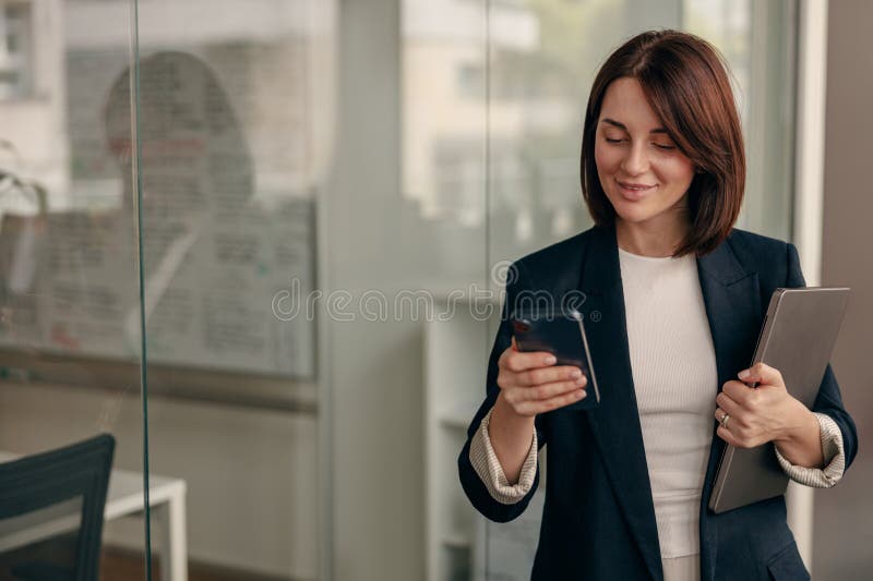 Professional Businesswoman Focused on Using Her Smartphone in a Modern ...