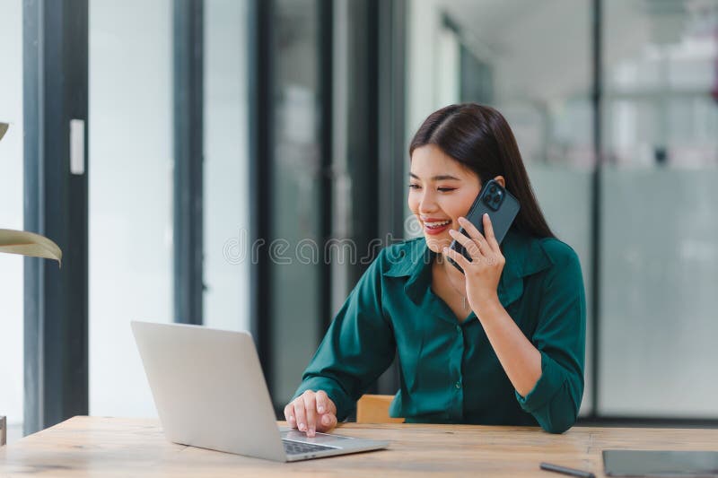 Professional Businesswoman in a Phone Conversation while Using Desktop ...