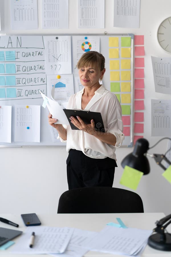Focused Businesswoman Reviewing Documents in Modern Office Stock Photo ...