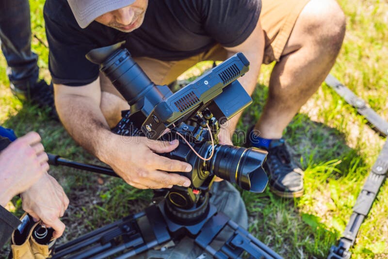 A Professional Cameraman Prepares a Camera and a Tripod before Shooting ...