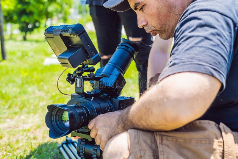 A Professional Cameraman Prepares a Camera and a Tripod before Shooting ...