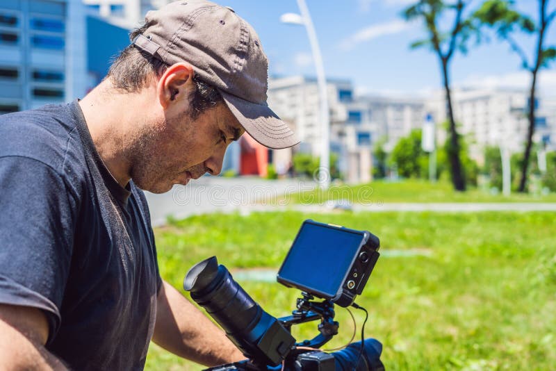 A Professional Cameraman Prepares a Camera and a Tripod before Shooting ...