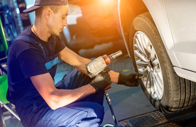 Mechanic working on wheels stock image. Image of hand - 23814447