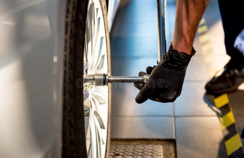 Mechanic working on wheels stock image. Image of hand - 23814447