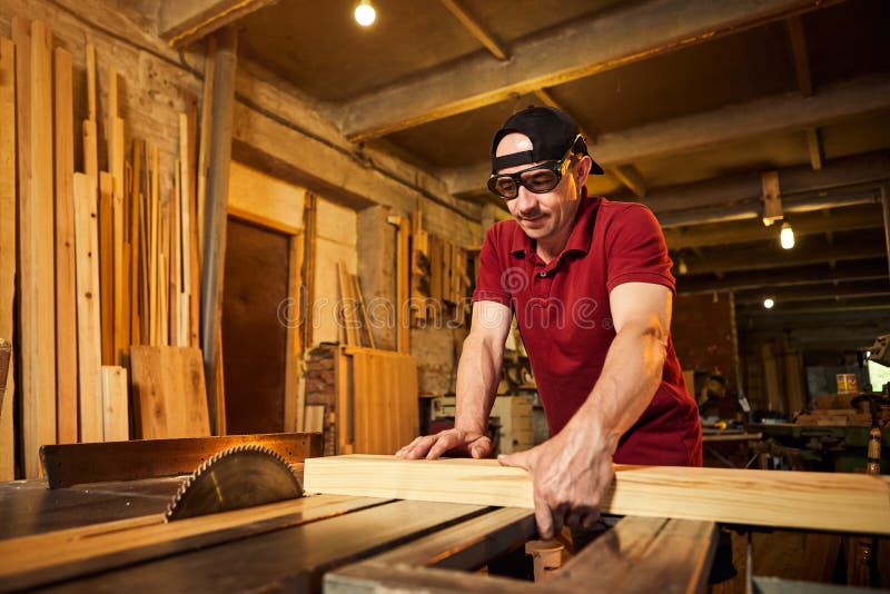 Professional Carpenter in Uniform Works on a Woodworking Machine at the ...
