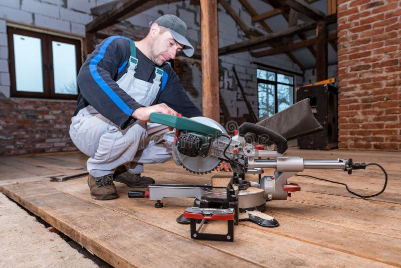 Carpenter using miter saw stock photo. Image of sawing - 214616132