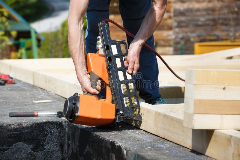Professional Carpenter Using Pneumatic Nail Gun Stock Photo - Image of ...