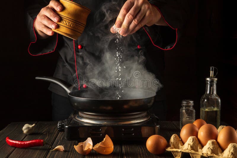 Professional Chef Adds Salt while Cooking Eggs or an Omelet in Pan ...