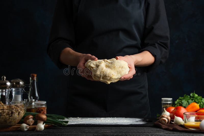 The Professional Chef Baker Keeps Dough for Pie or Pizza on Dark Blue ...