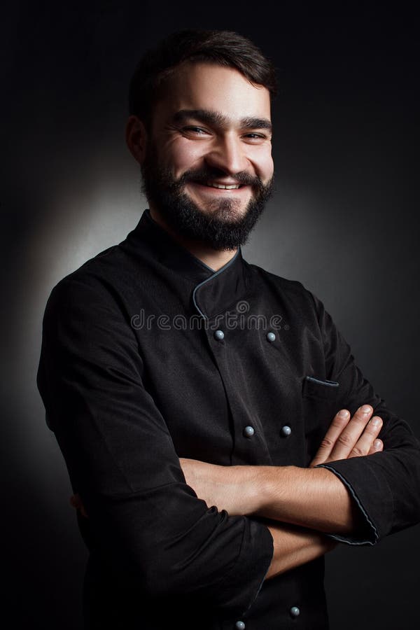 Professional Chef with a Beard in a Black Uniform with a Kitchen Knife ...