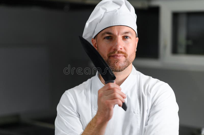 Professional Chef with a Beard in a White Uniform with a Kitchen Knife ...