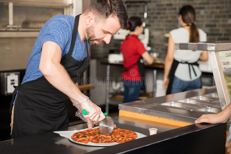 Professional Chef Cutting Pizza Slices Using a Roller Cutter Stock ...