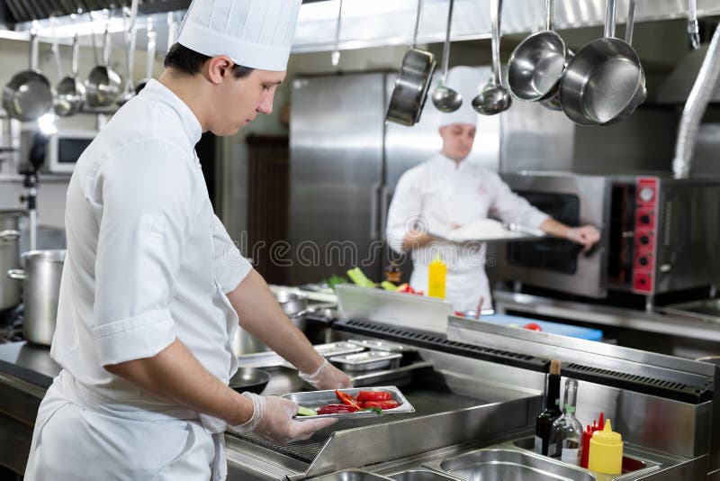 Professional Chef in the Kitchen Roasts Vegetables on the Grill. Stock ...