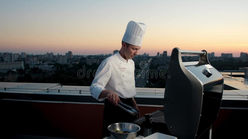 A Professional Chef Prepares a Barbecue on the Rooftop of a Skyscraper ...