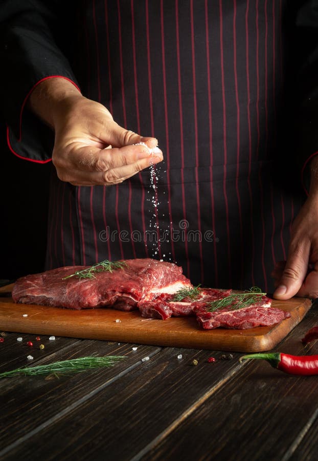 Professional Chef Salts Raw Fresh Beef before Roasting or Grilling ...