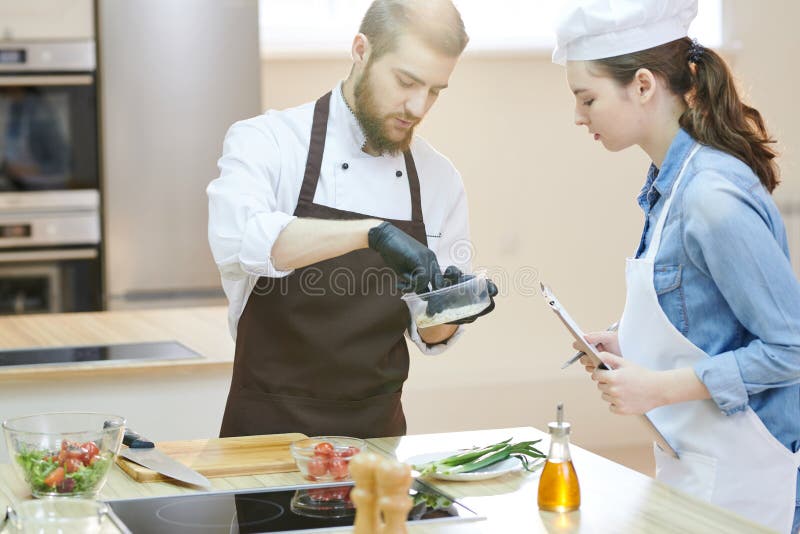Professional Chef Working in Kitchen with Female Assistant Stock Photo ...