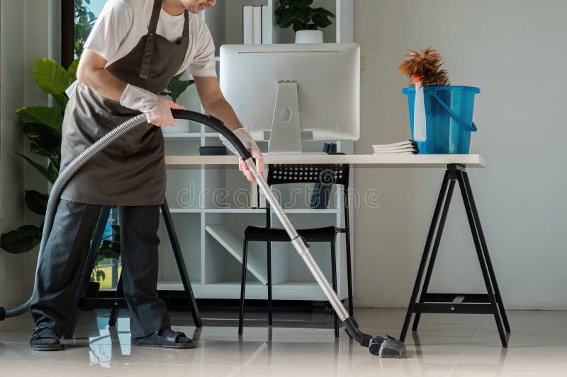 Professional Cleaner Vacuuming Modern Office Space with Desk and ...