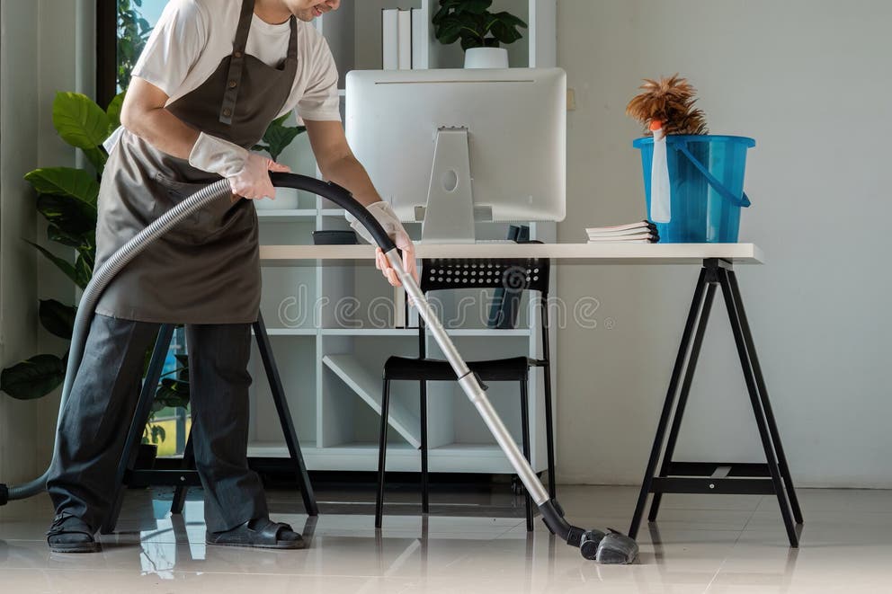 Professional Cleaner Vacuuming Modern Office Space with Desk and ...