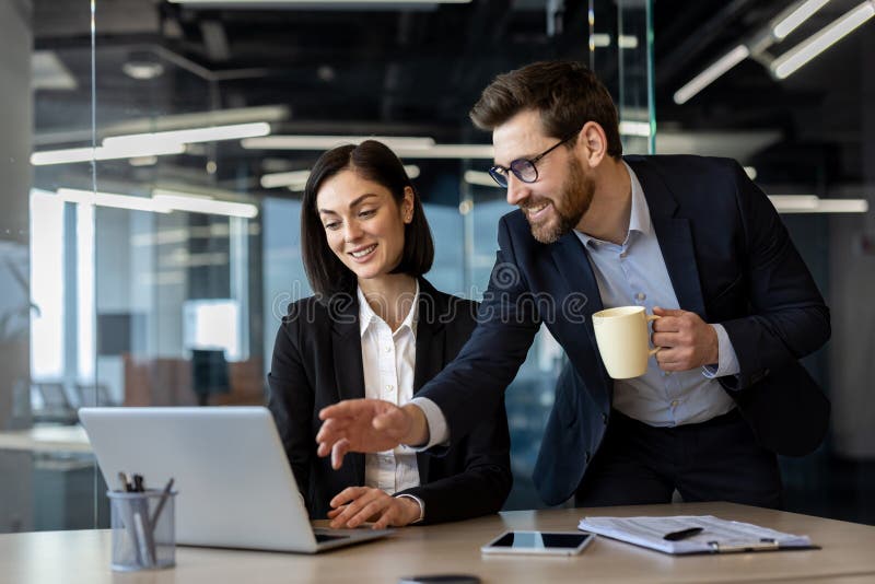 Professional Colleagues Collaborating on Laptop in Modern Office ...