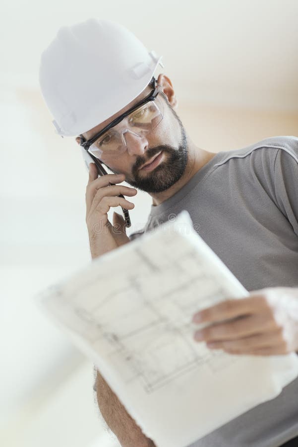 Professional Construction Worker Checking a Project and Calling Stock ...