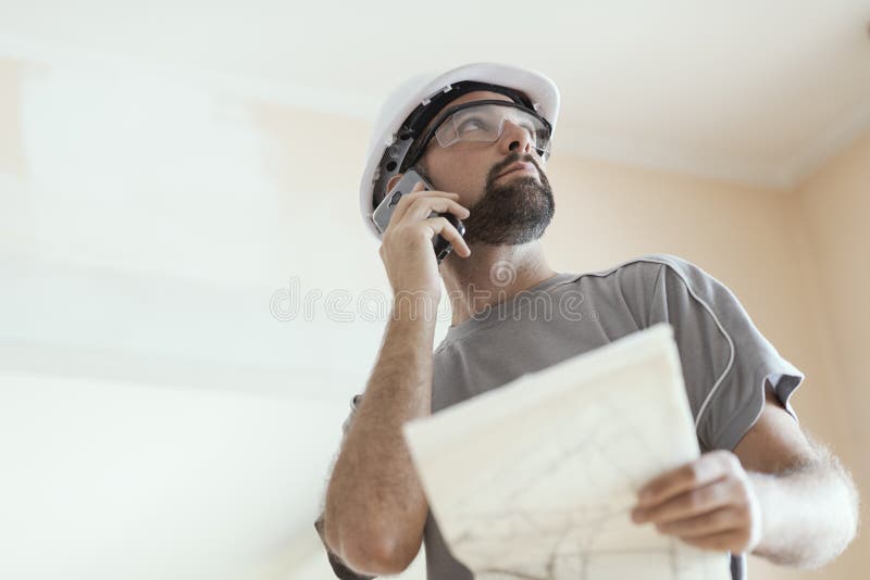 Professional Construction Worker Checking a Project and Calling Stock ...